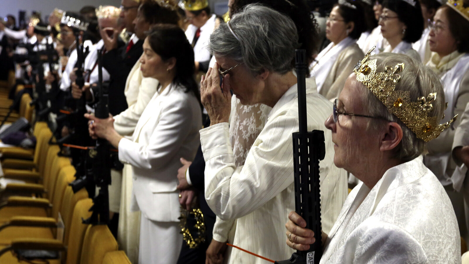 A Christian woman holds a rifle at her church in Newfoundland, Pa.