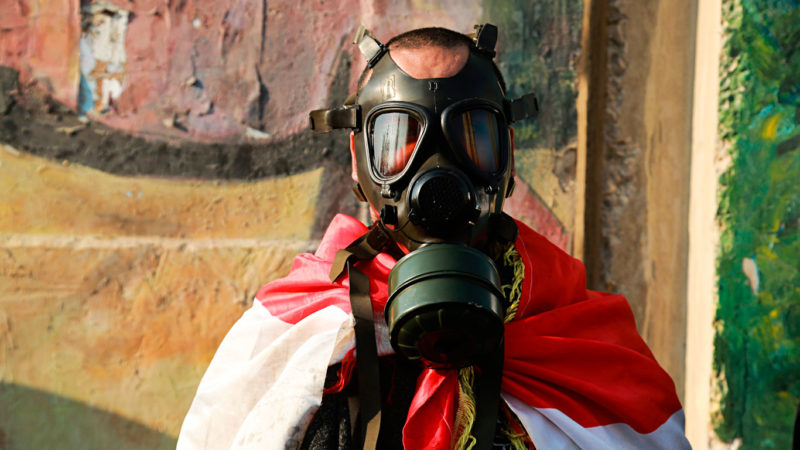 protester wearing gas mask during anti-government protest in Iraq